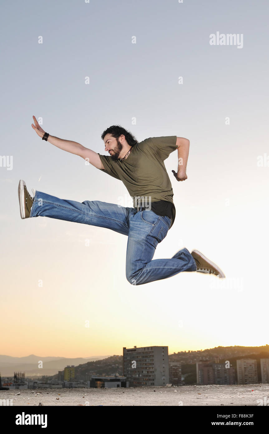 young man jumping in air at sunset outdoor Stock Photo - Alamy