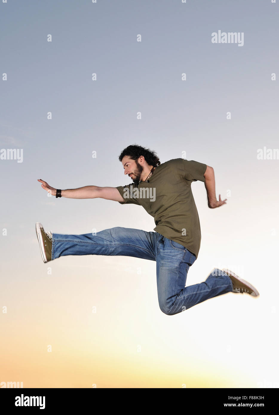 young man jumping in air at sunset outdoor Stock Photo - Alamy