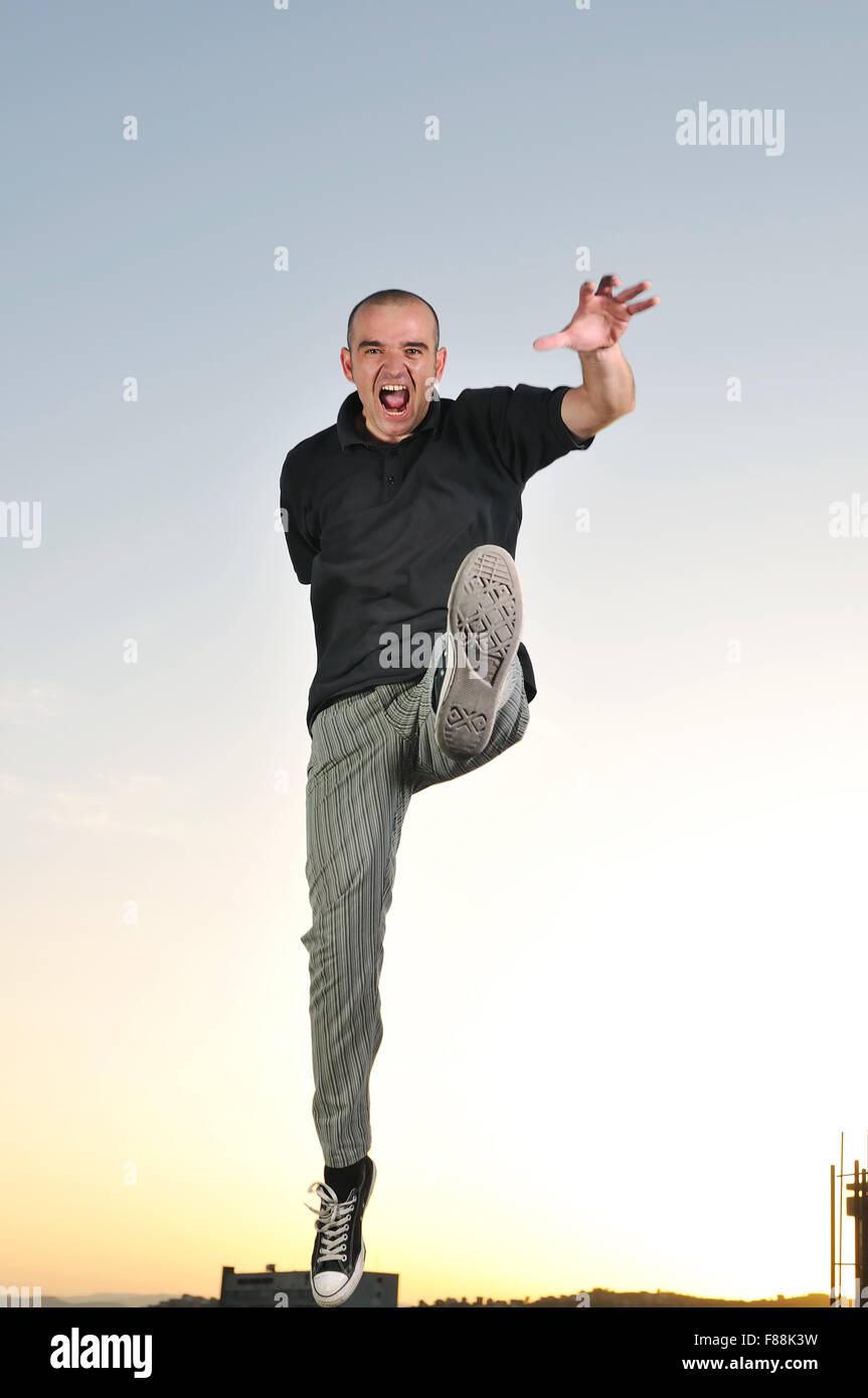young man jumping in air at sunset outdoor Stock Photo - Alamy