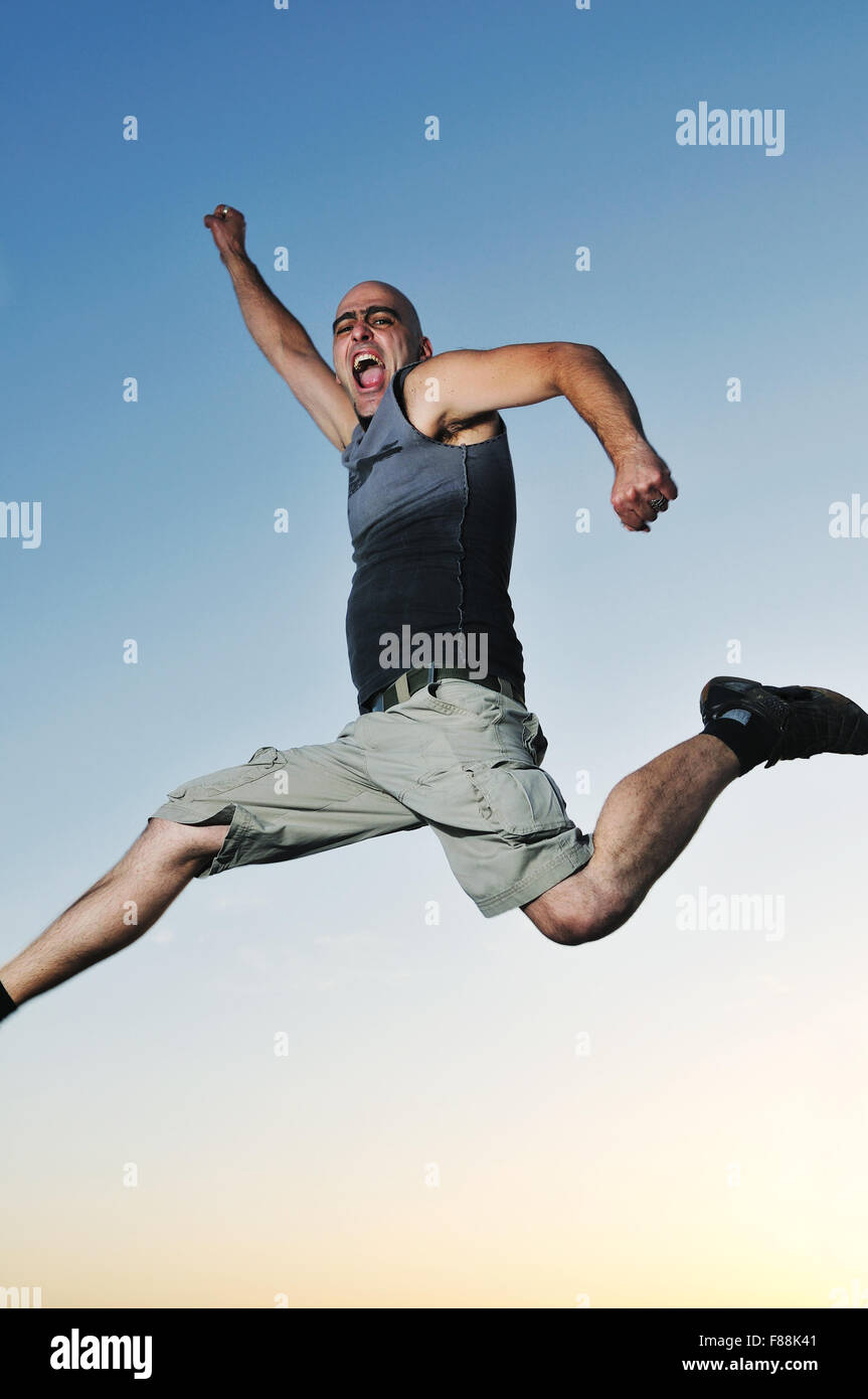 young man jumping in air at sunset outdoor Stock Photo - Alamy