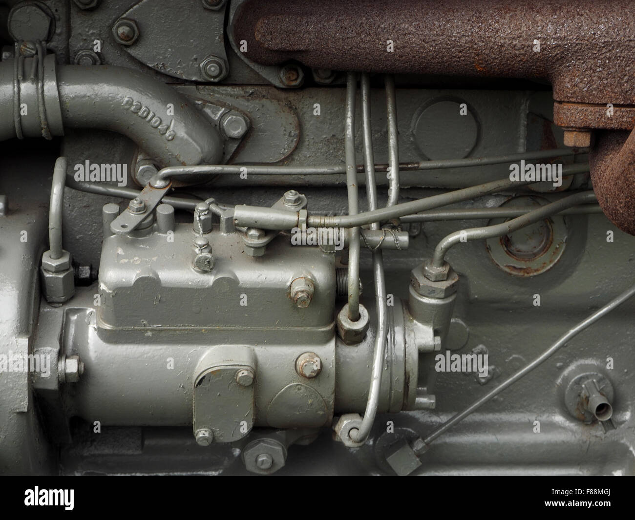 detail of grey gray painted engine of tractor with pipework and cables ...
