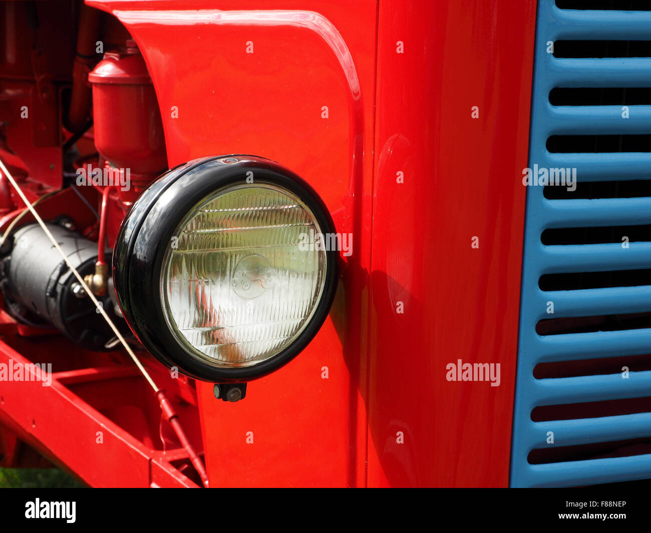 detail of gleaming red and blue paintwork of classic tractor in ...