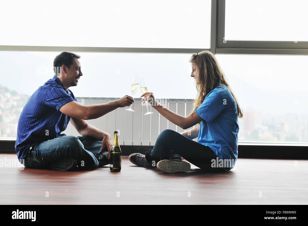 happy couple at big bright comfort apartment celebrate with glasses of ...