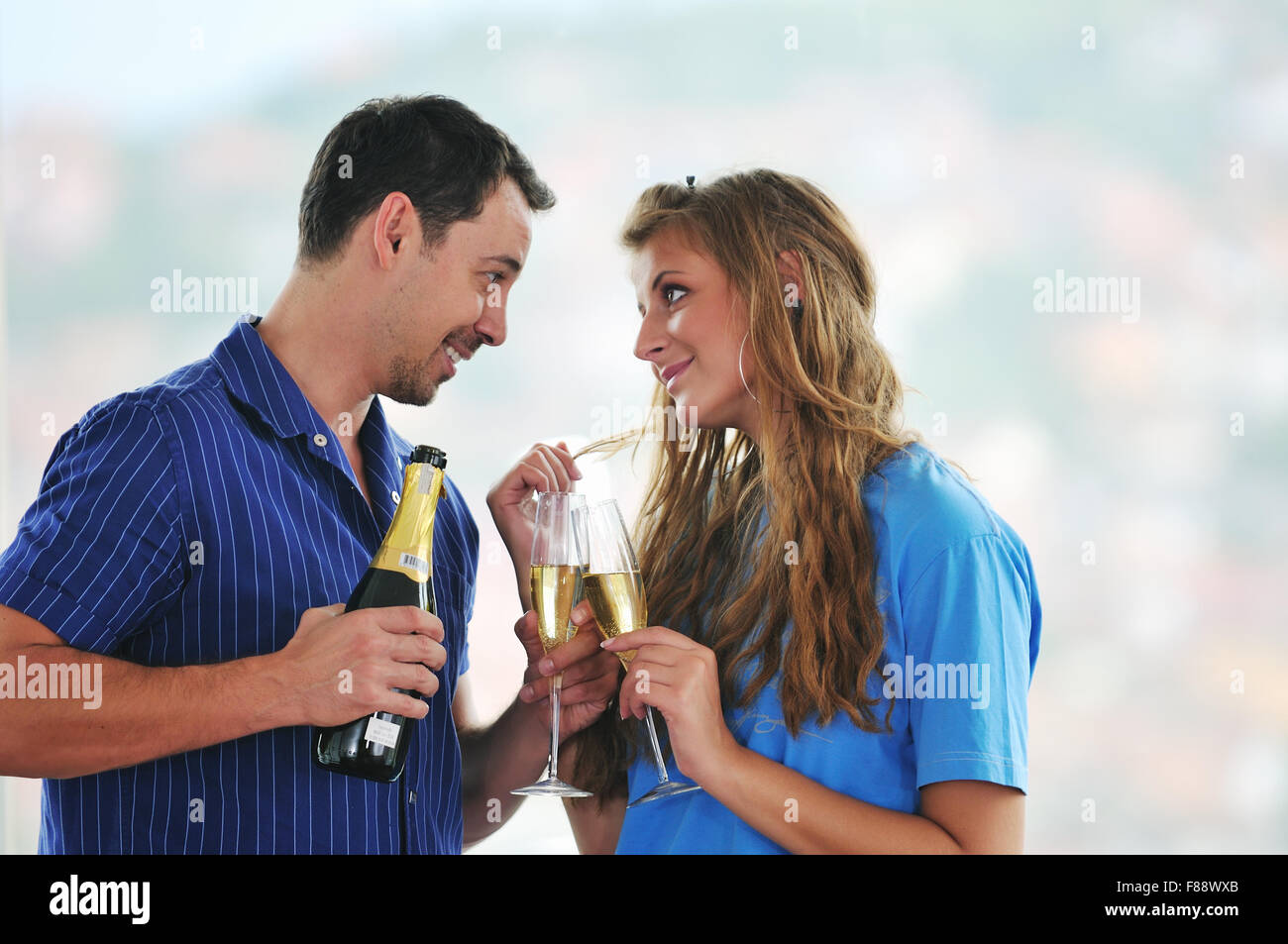 happy couple at big bright comfort apartment celebrate with glasses of ...