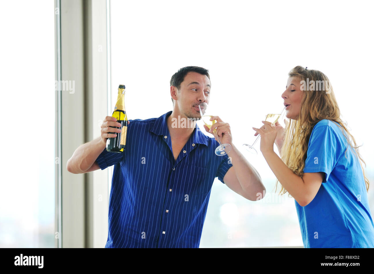 happy couple at big bright comfort apartment celebrate with glasses of ...