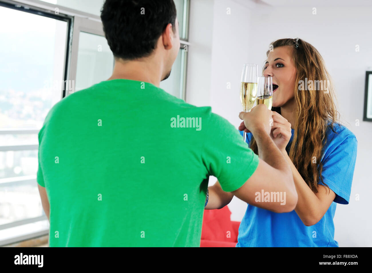 happy couple at big bright comfort apartment celebrate with glasses of ...