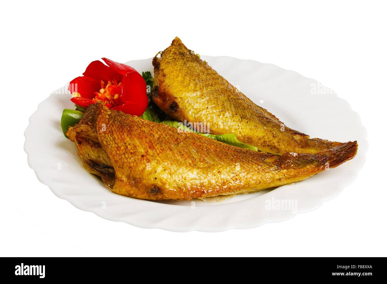 grilled fish with greens on the plate, isolated on white background ...