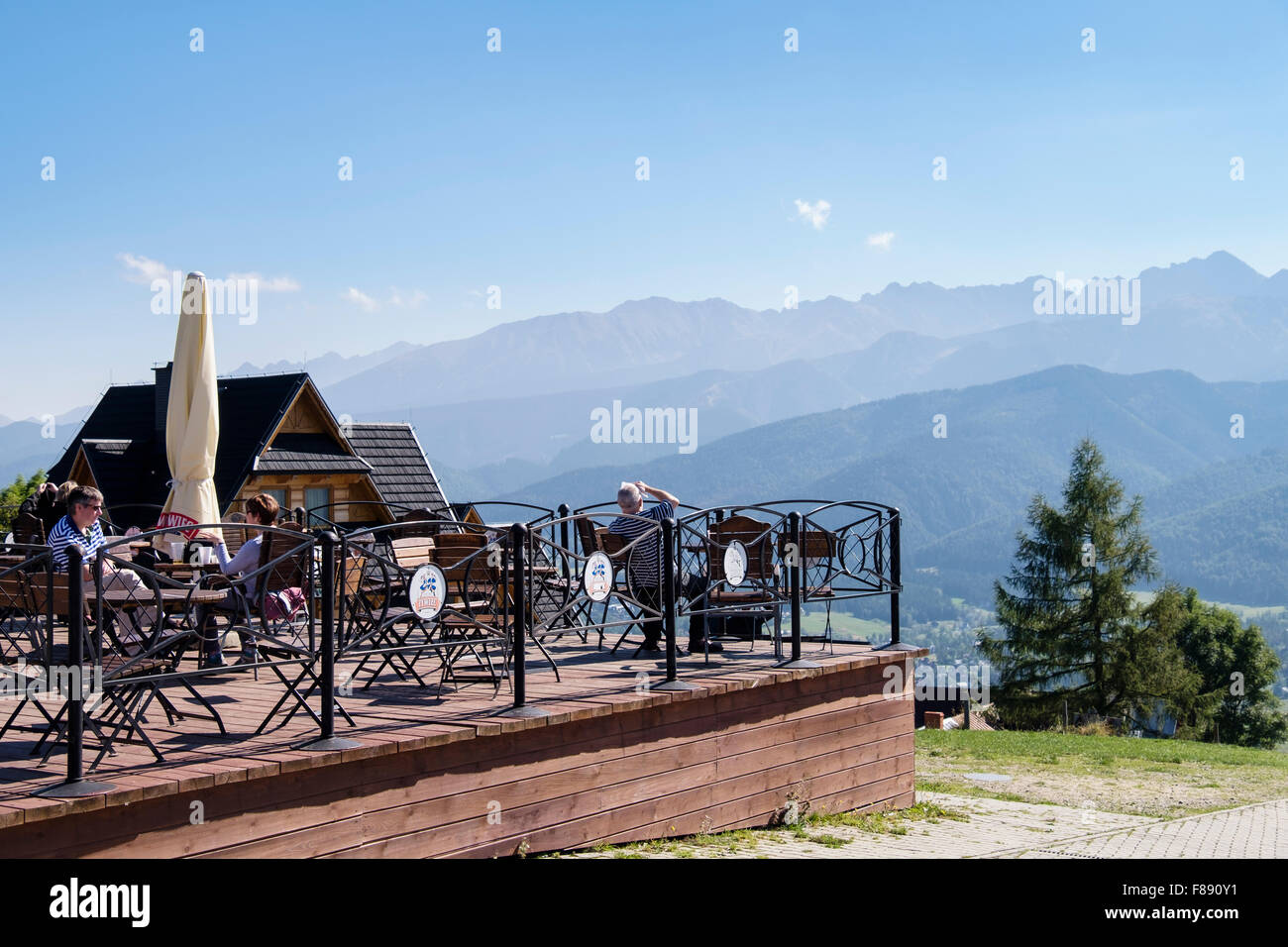 People in cafe terrace with view overlooking High Tatra Mountains ...