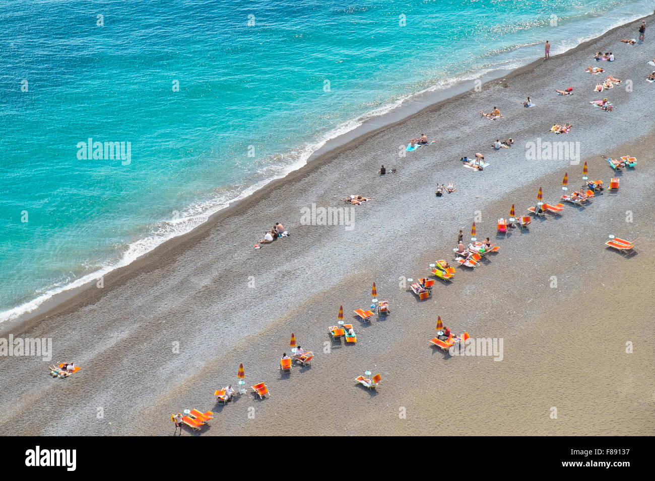 Sunbathers on beach chairs lined up, on the Amalfi coast at Positano ...