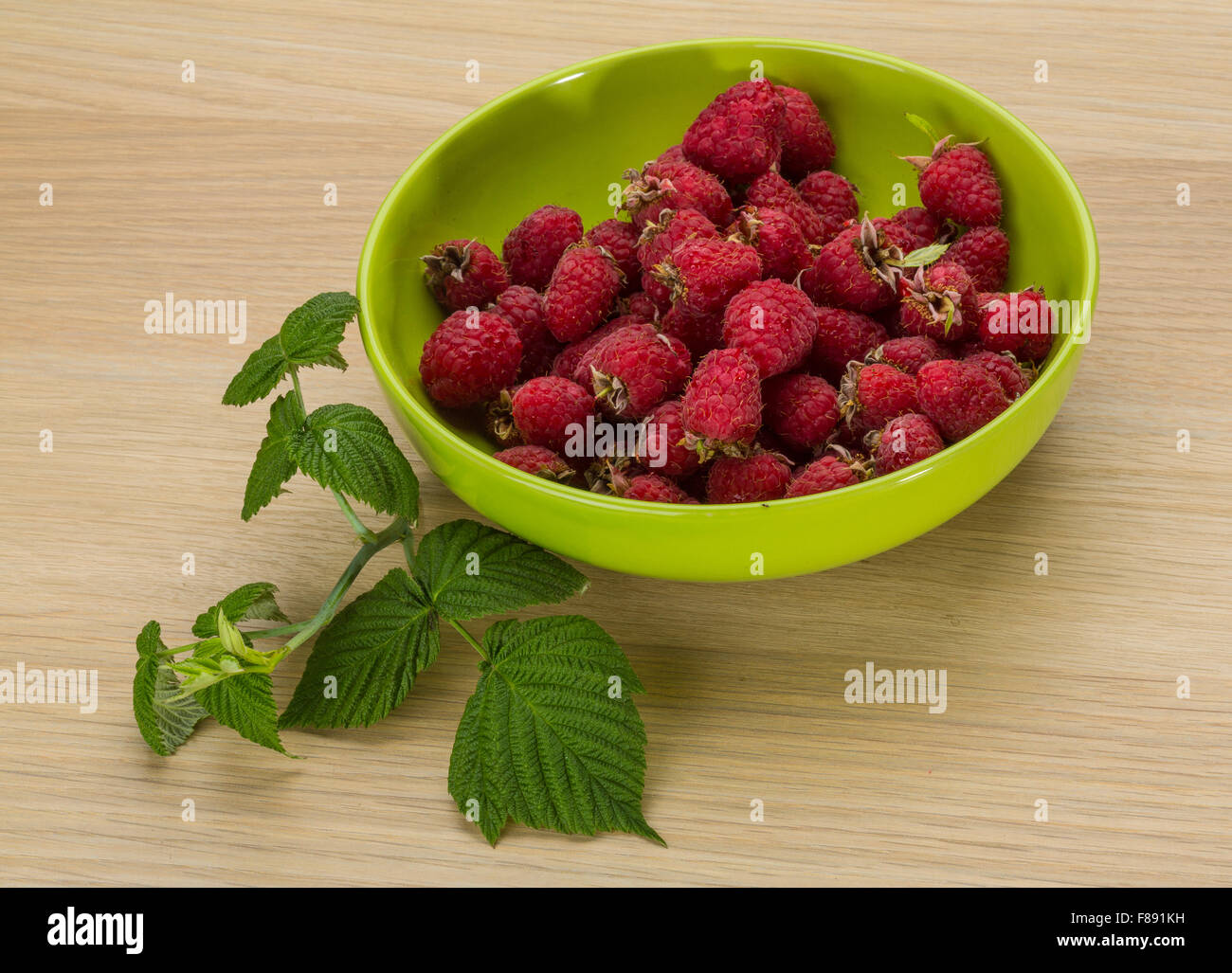 Raspberry in the bowl with leaves Stock Photo - Alamy