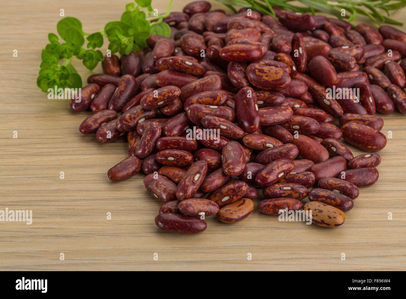Raw beans with herbs on the desk Stock Photo - Alamy