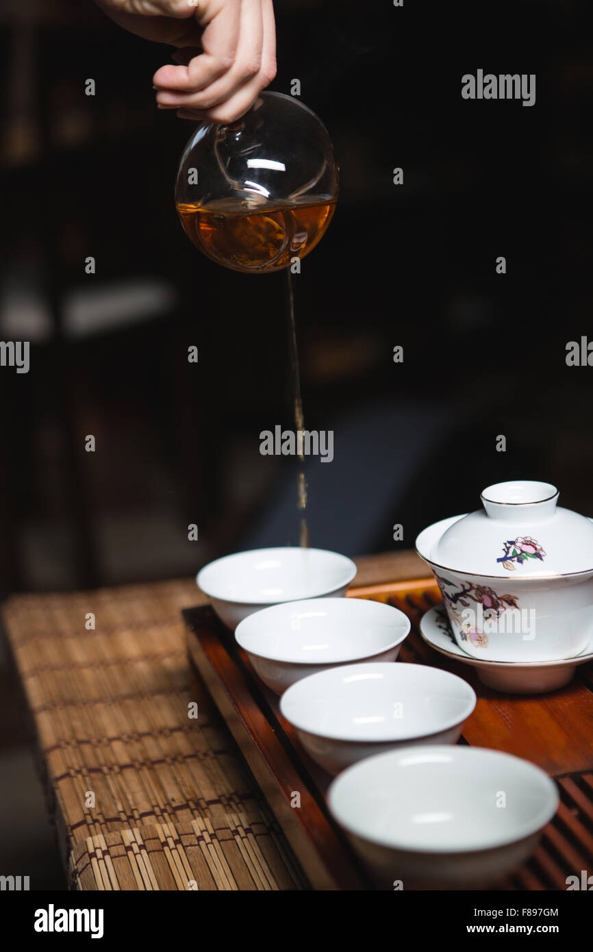 Hands pouring tea in cups Stock Photo - Alamy