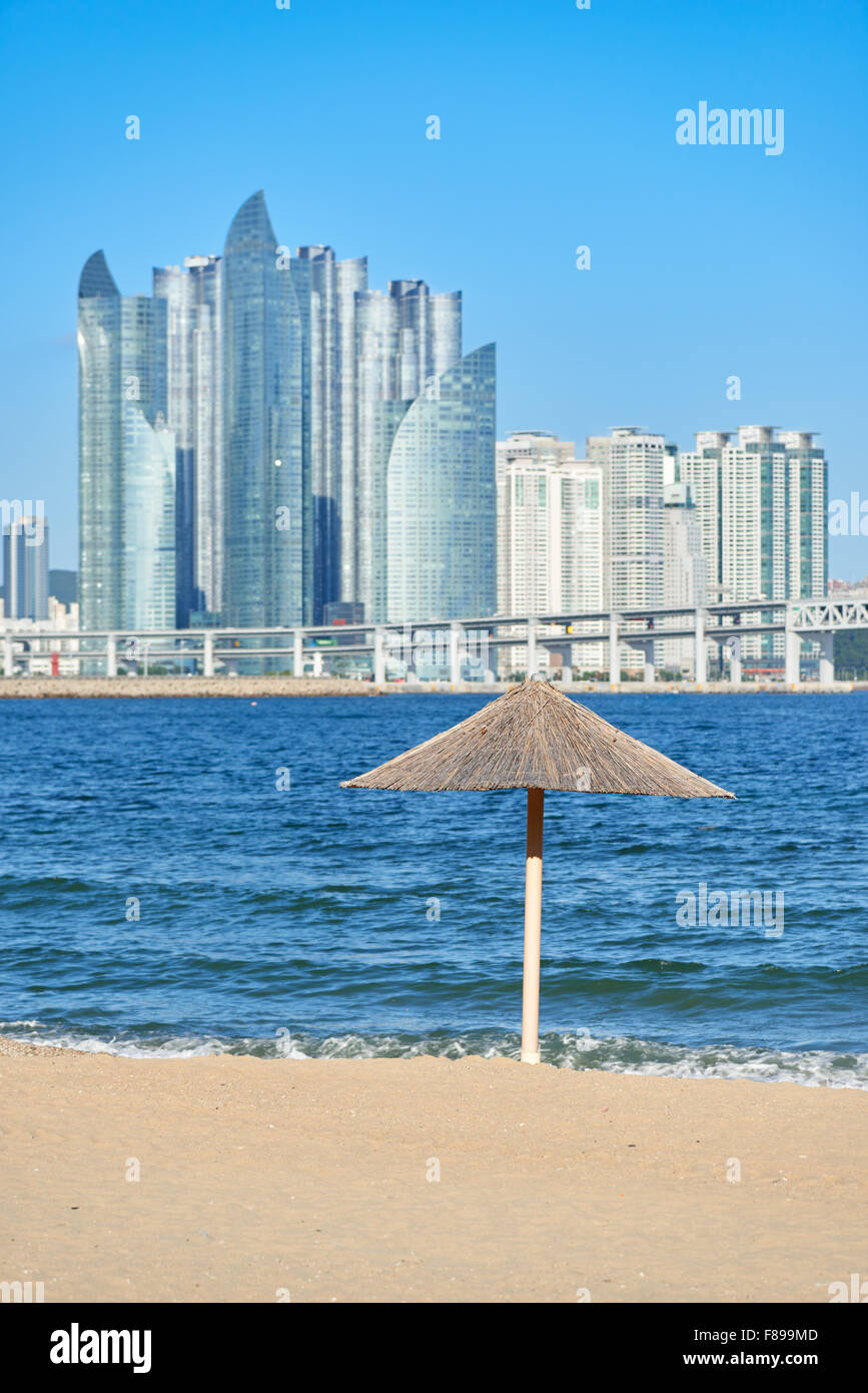straw umbrella at Gwangalli beach with modern buildings in Marine city ...