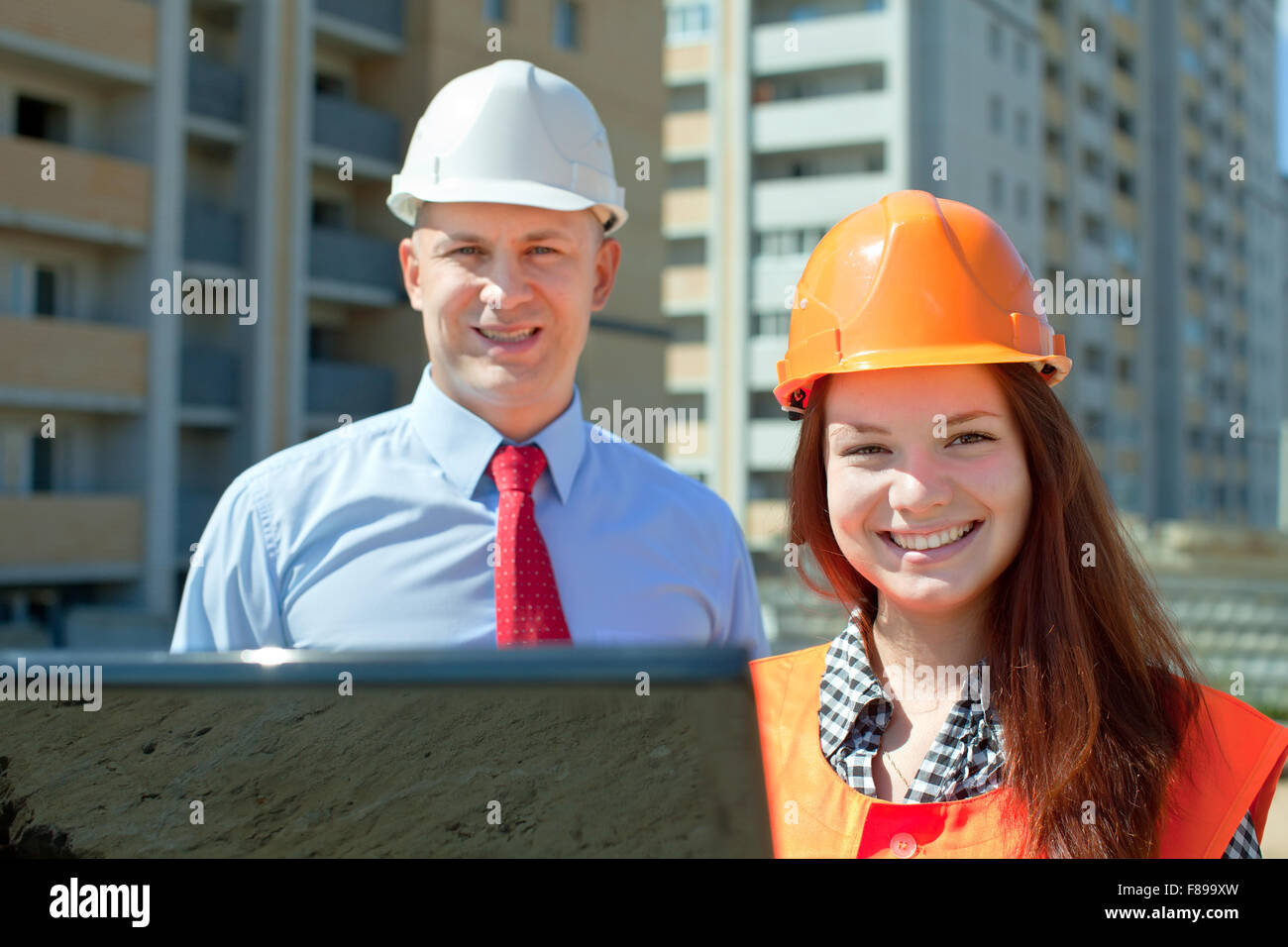 Portrait of two builders works at construction site Stock Photo - Alamy