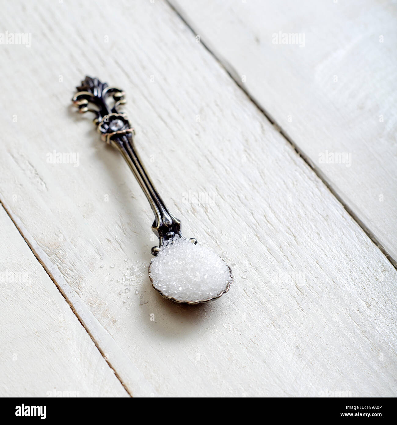 Sugar in spoon on white wooden background.close up Stock Photo - Alamy