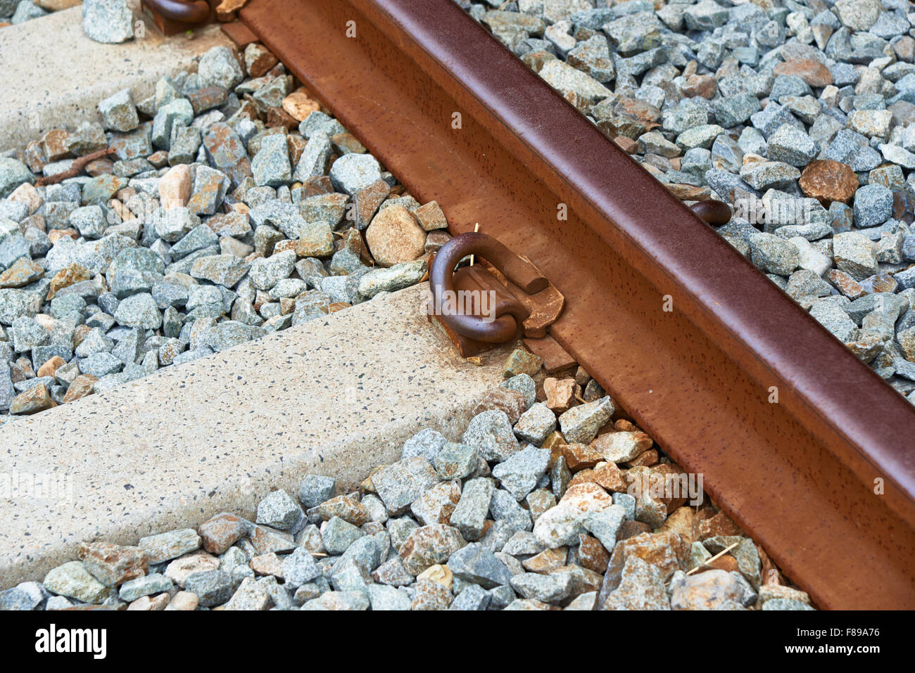 Closeup of rusty railroad and concrete reinforced pavement on a ...