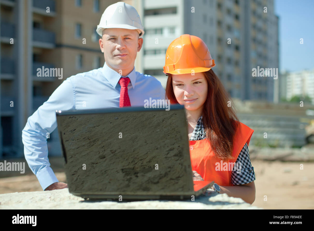 Portrait of two builders works at construction site Stock Photo - Alamy