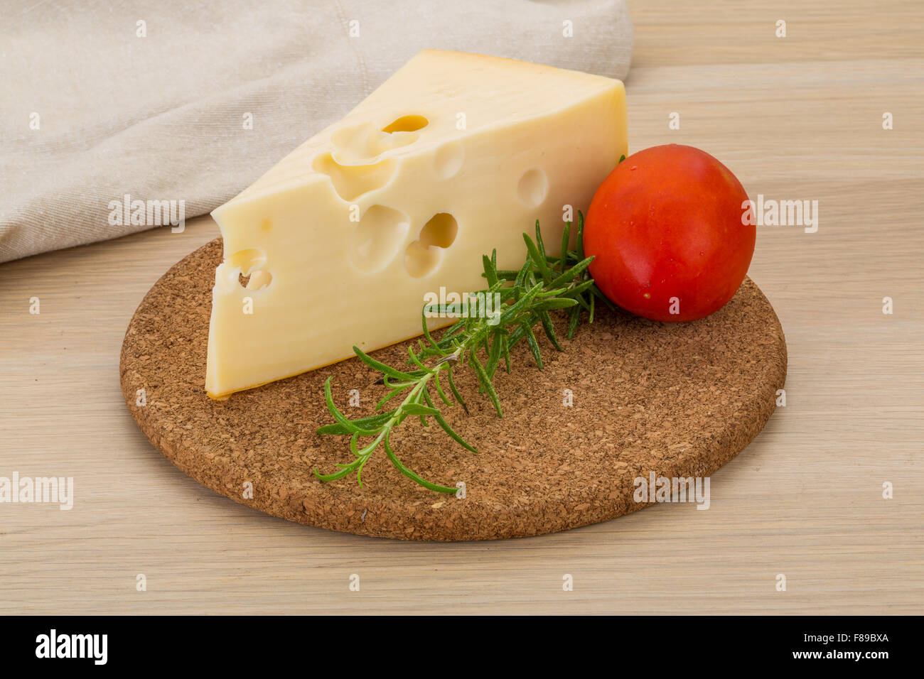 Yellow Cheese maasdam - on the board with herbs Stock Photo - Alamy