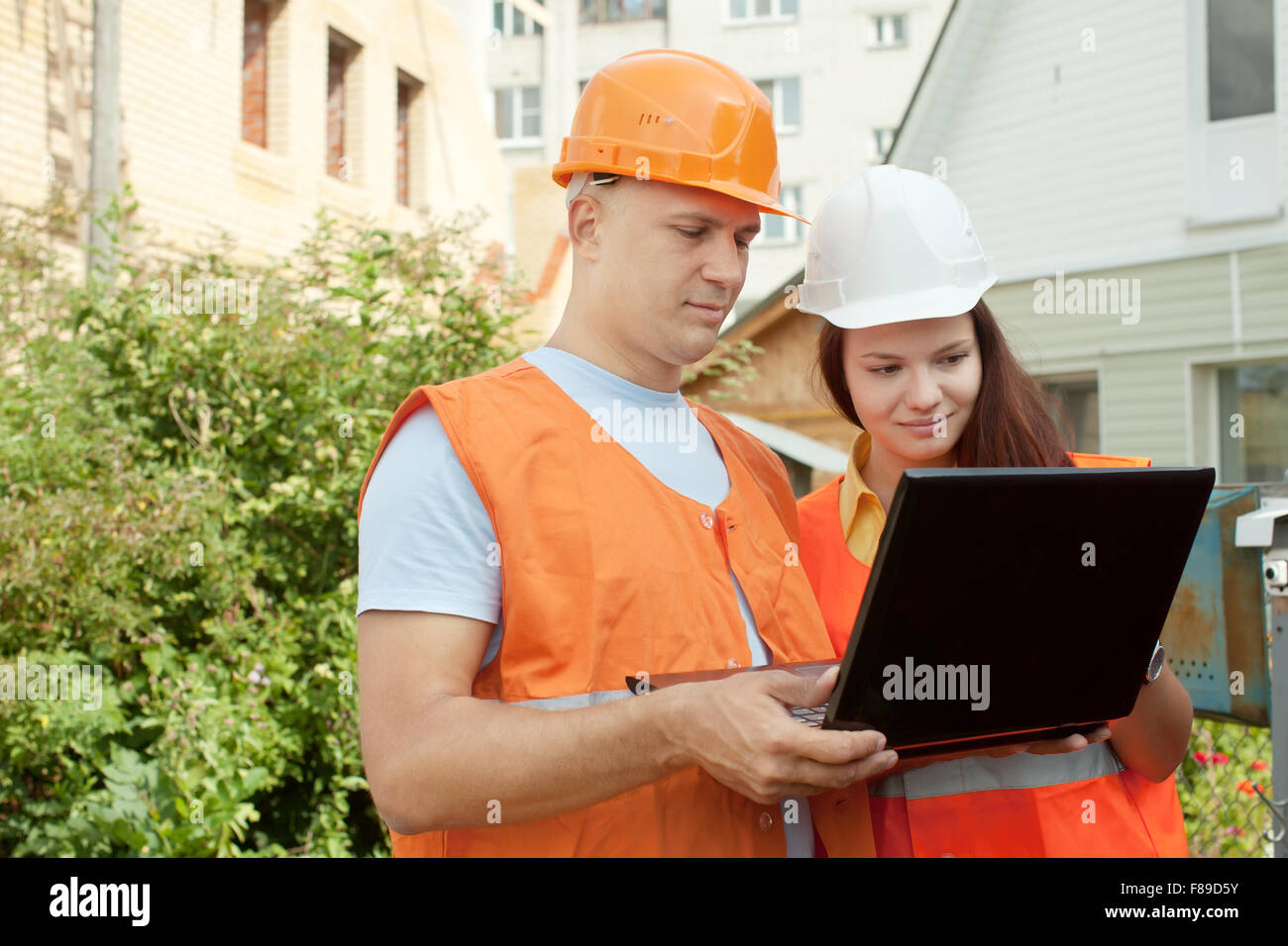 Portrait of two builders works at construction site Stock Photo - Alamy