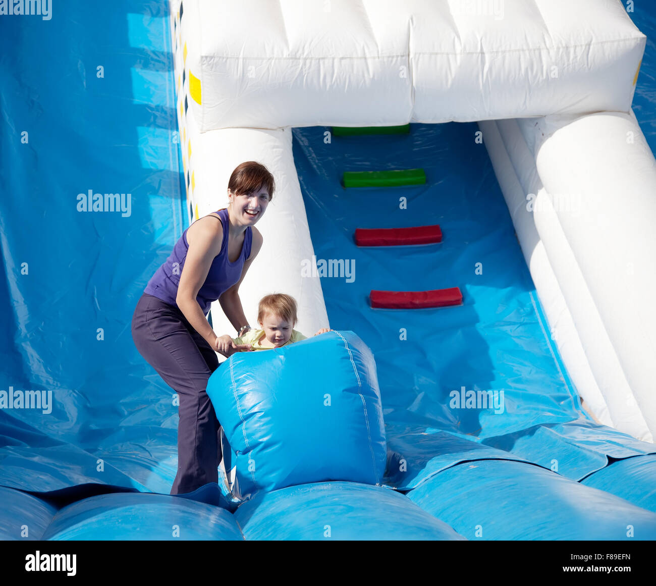 happy mother with toddler on slide playground area Stock Photo - Alamy
