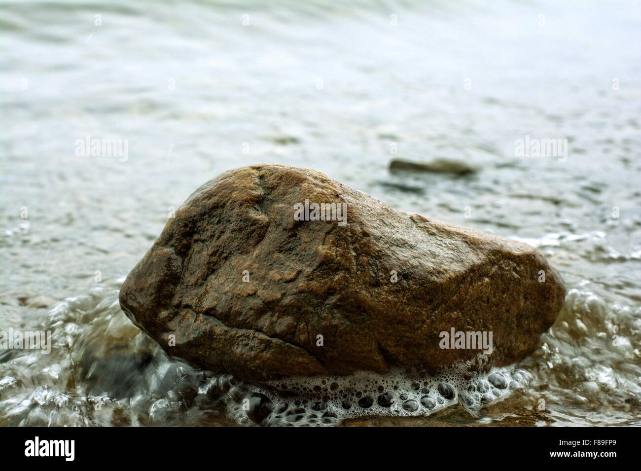 Rock washed up on a lake's beach Stock Photo - Alamy