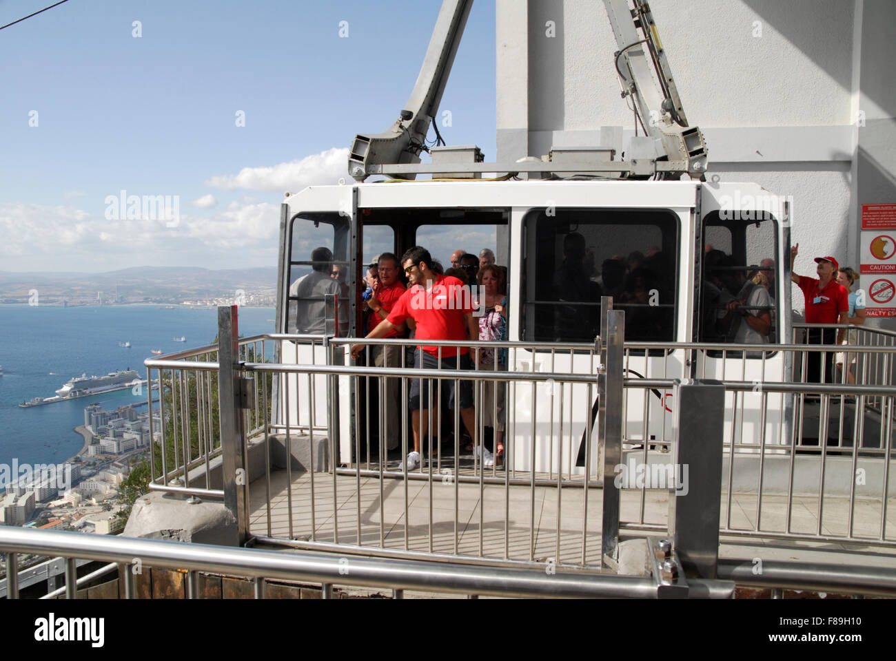 Attendant at the door of a cable car at the top station in Gibraltar ...