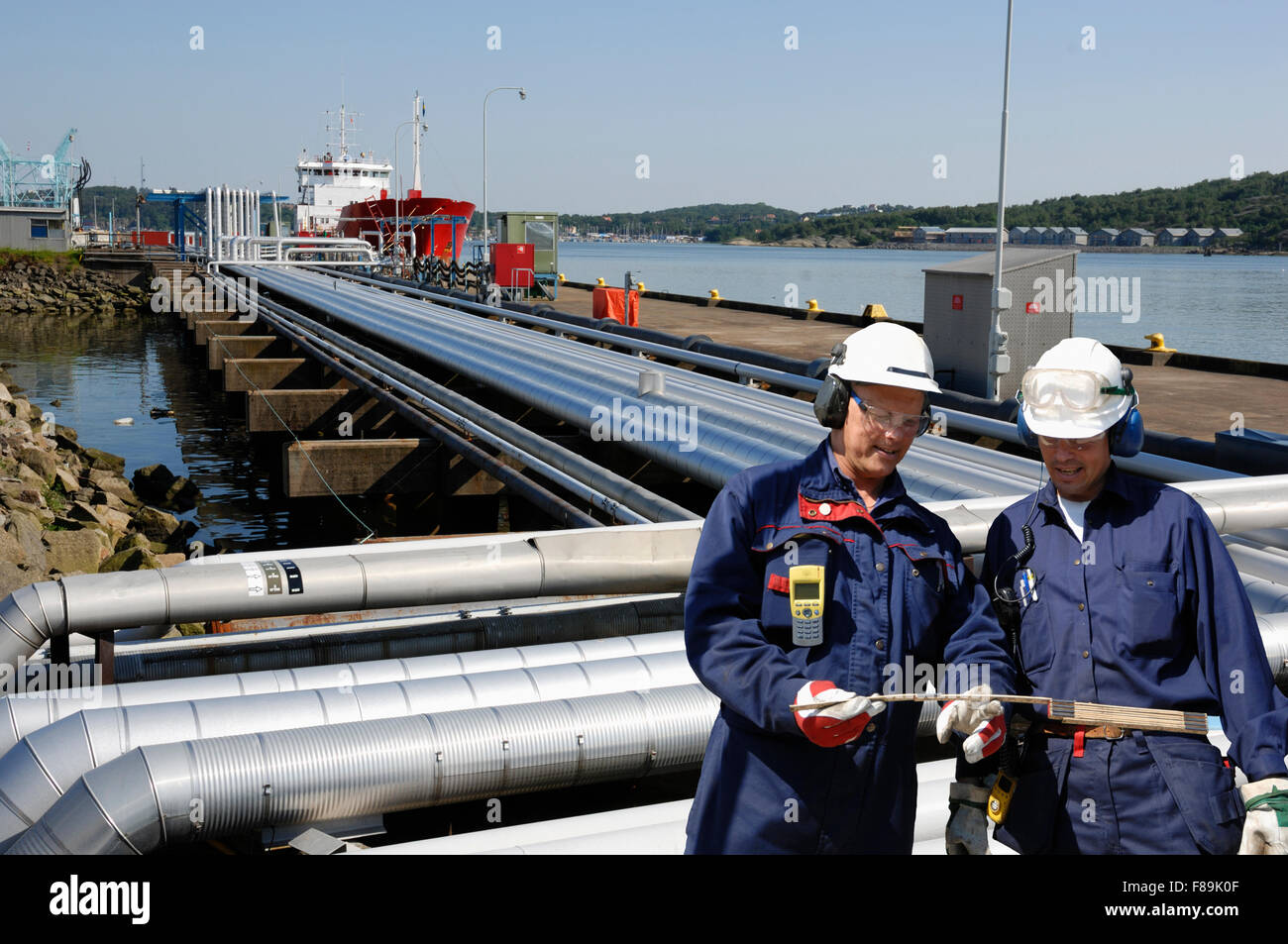 oil and gas workers with pipelines and ship Stock Photo - Alamy
