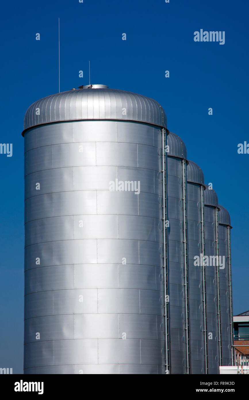 Bright silver industrial tanks in front of a blue sky Stock Photo - Alamy