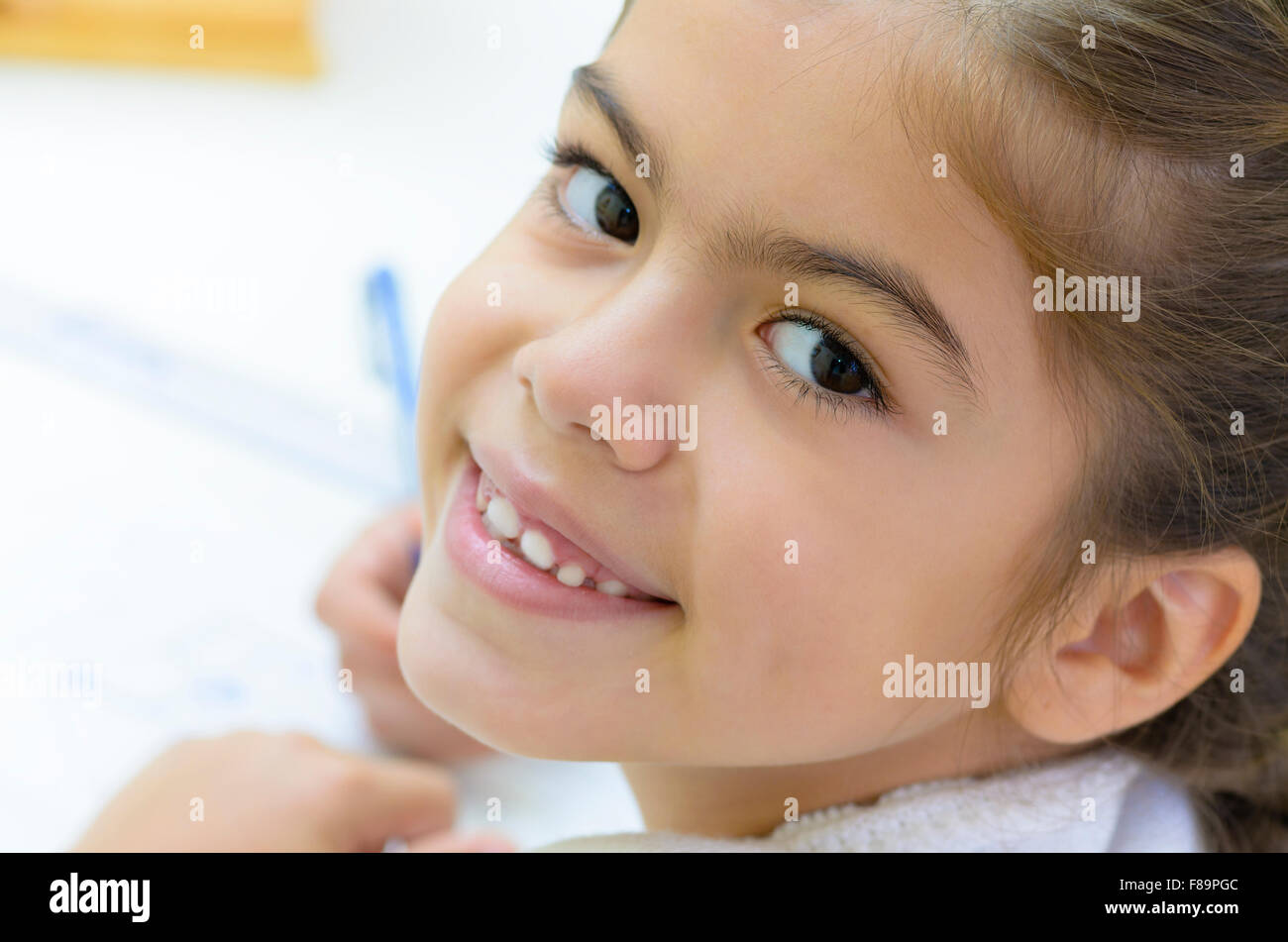Smiling girl writing at school Stock Photo - Alamy