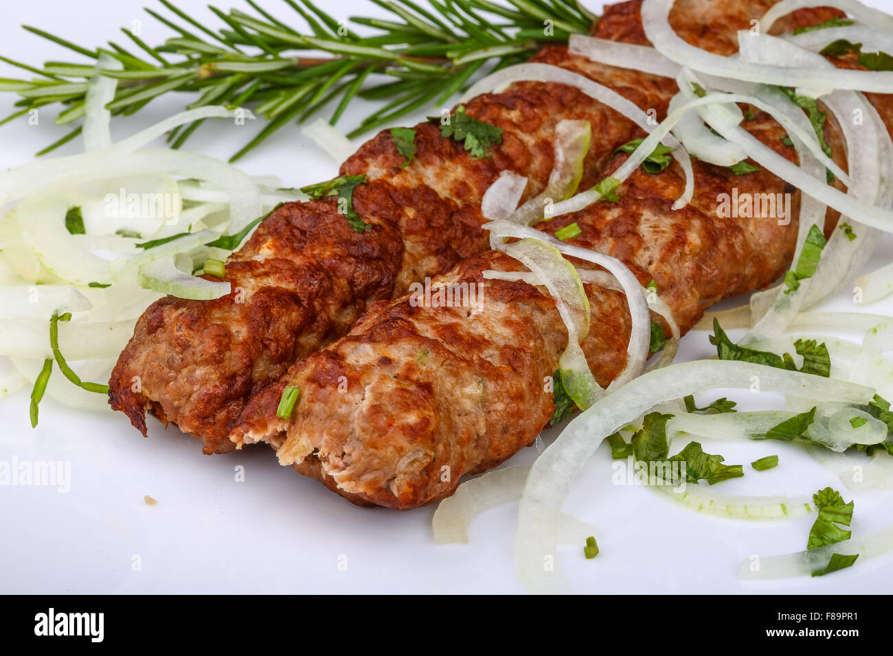Kebab barbecue with rosemary and onion rings on the wood background ...