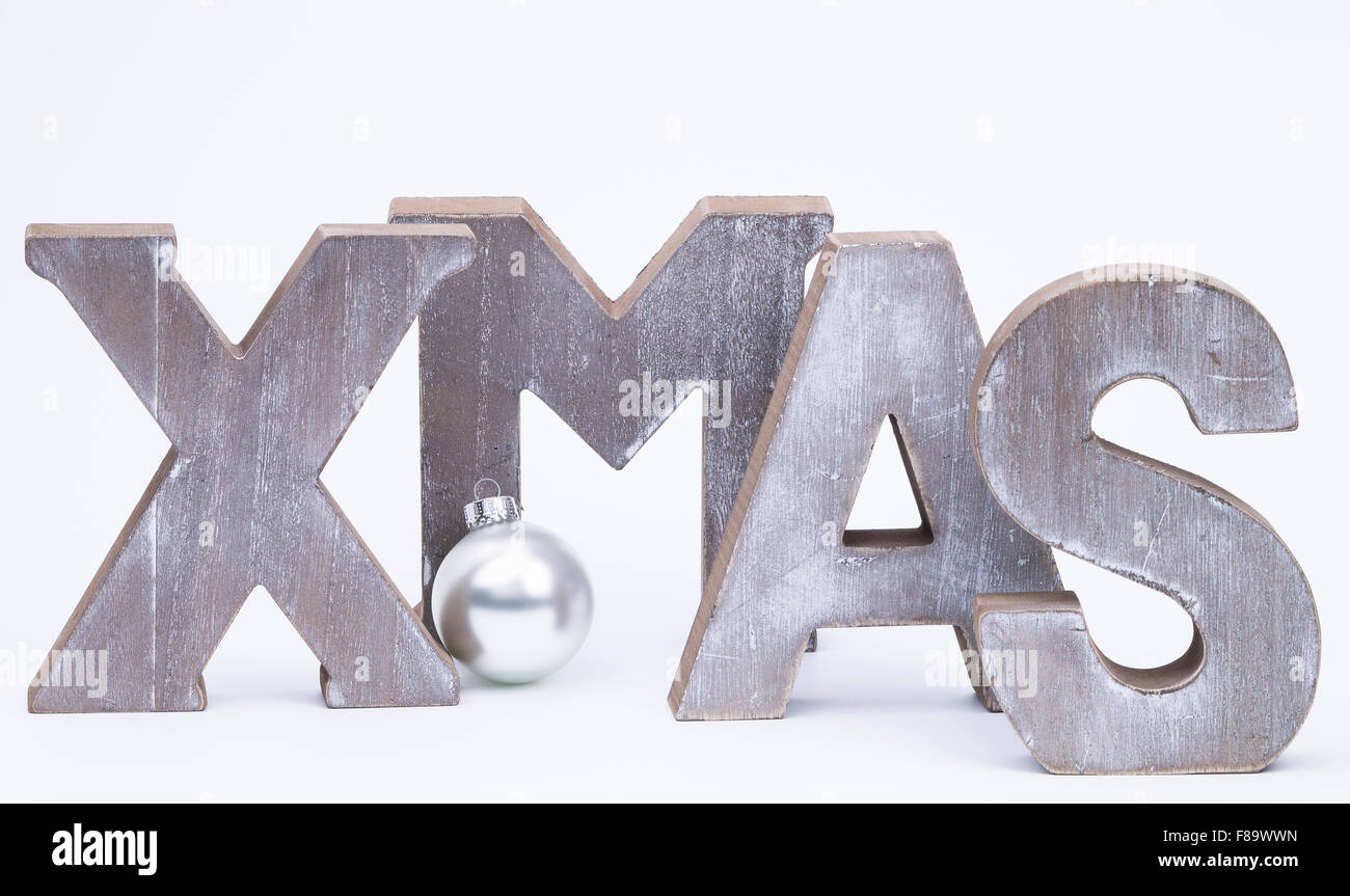 Capital letters forming the word x-mas with silver Christmas ball over ...