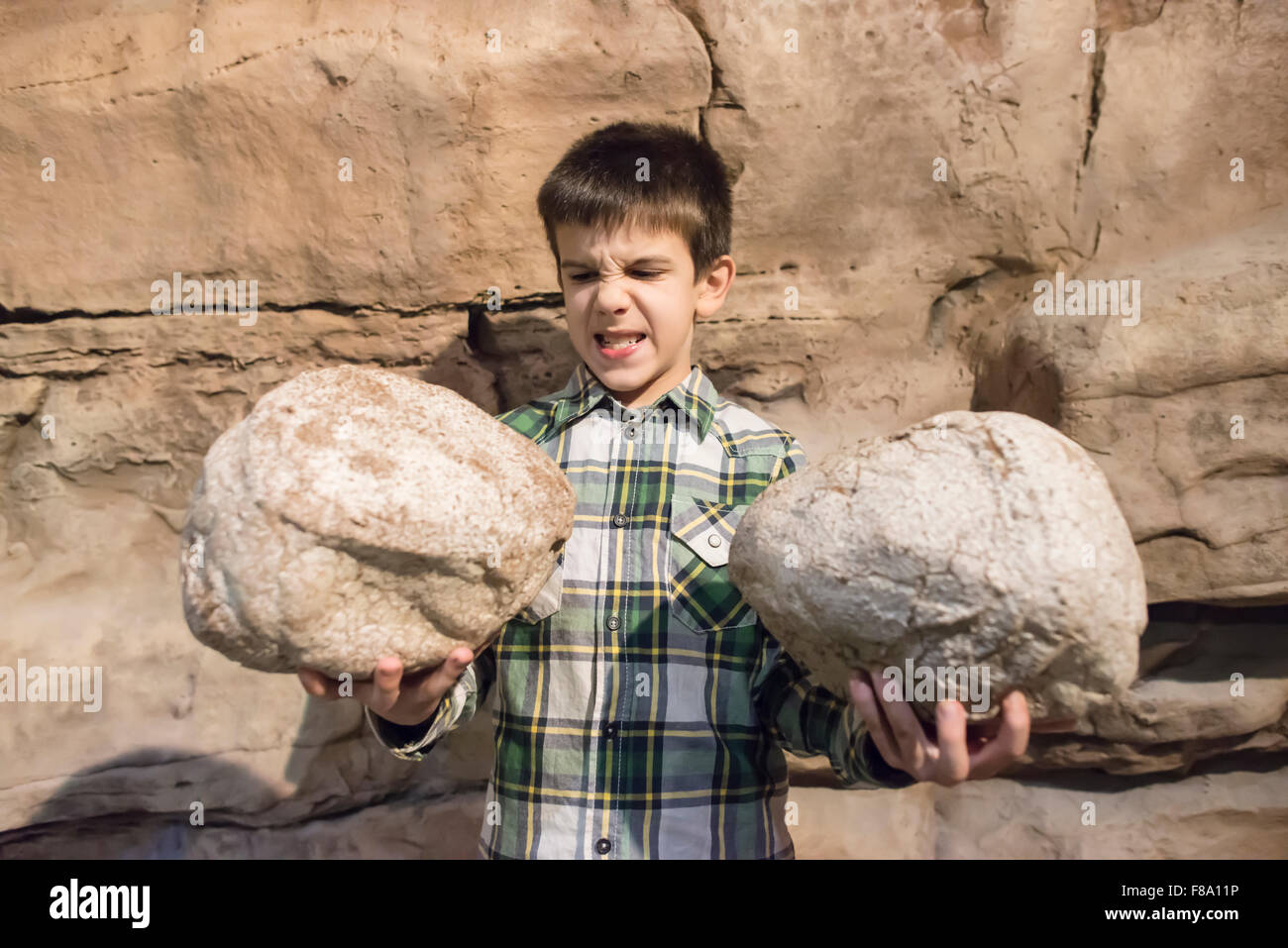 Strong child holds heavy stones Stock Photo - Alamy
