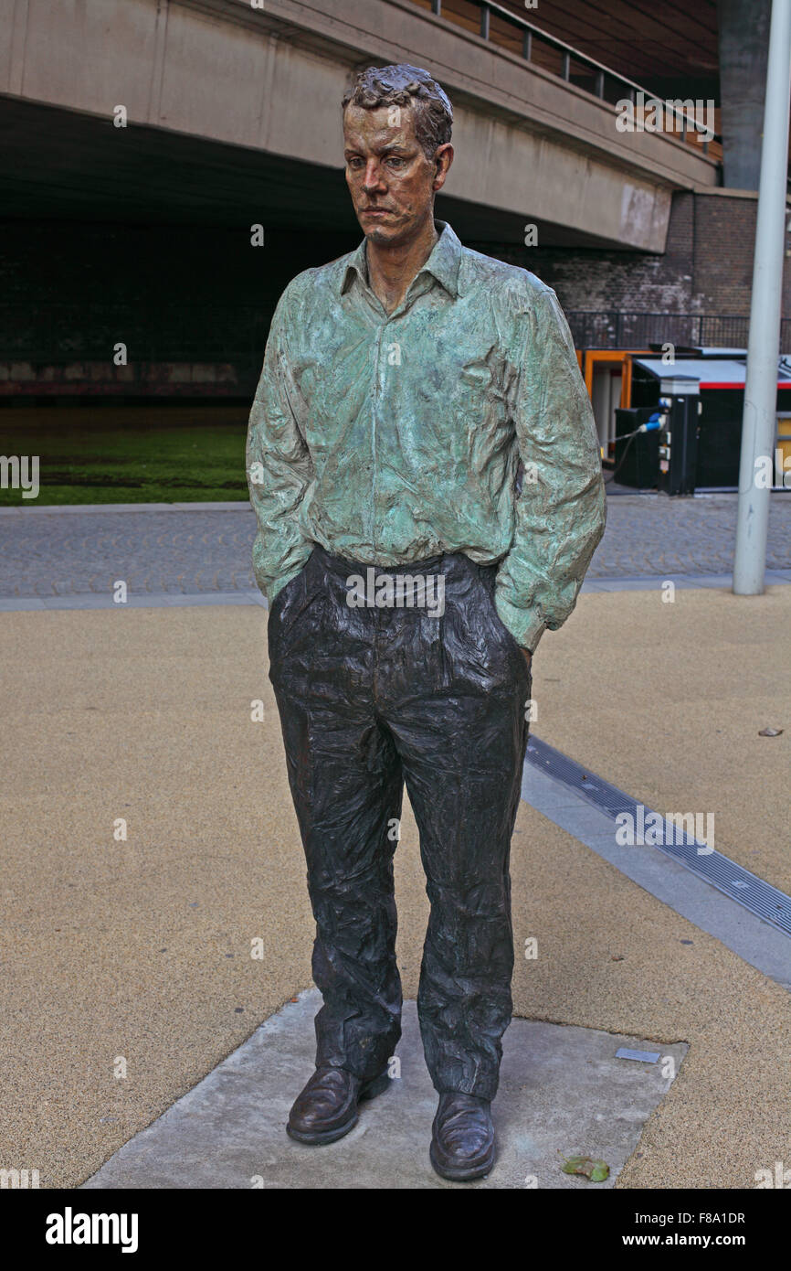 A life size man moulded from concrete and painted standing facing ...