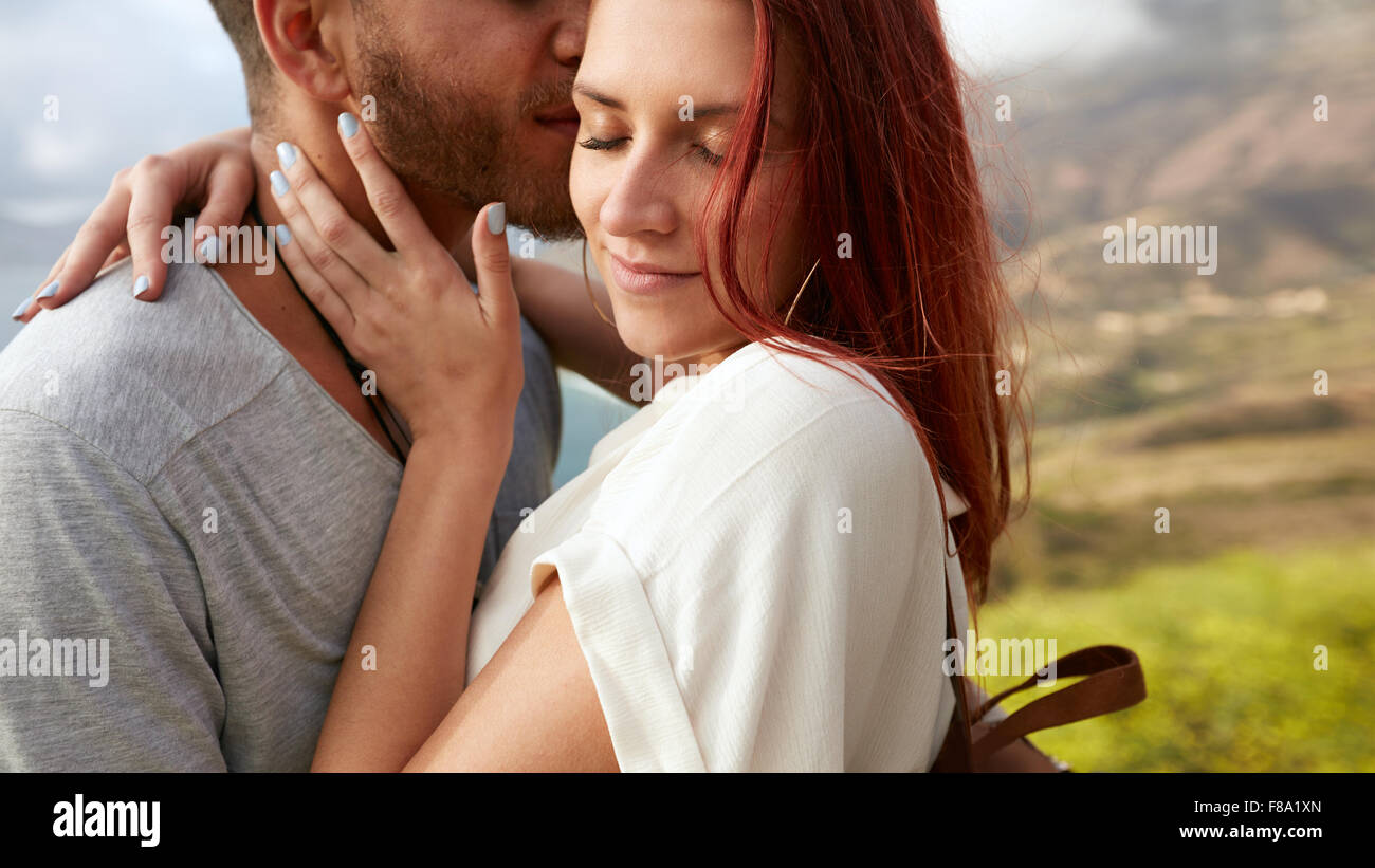 Affectionate young couple embracing each other outdoors. Close up shot ...