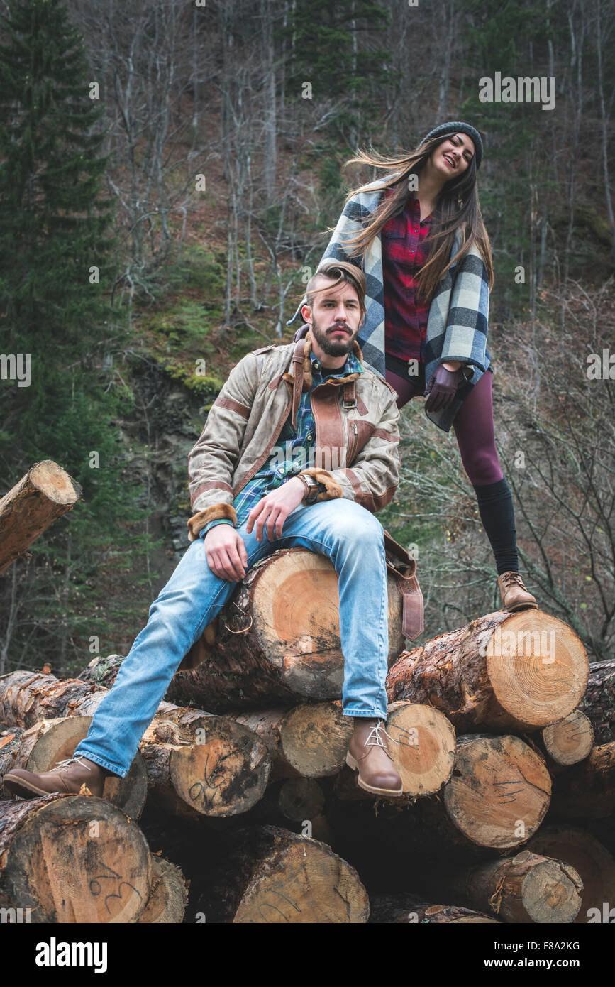 Young woman and men on wood logs in the forest Stock Photo - Alamy