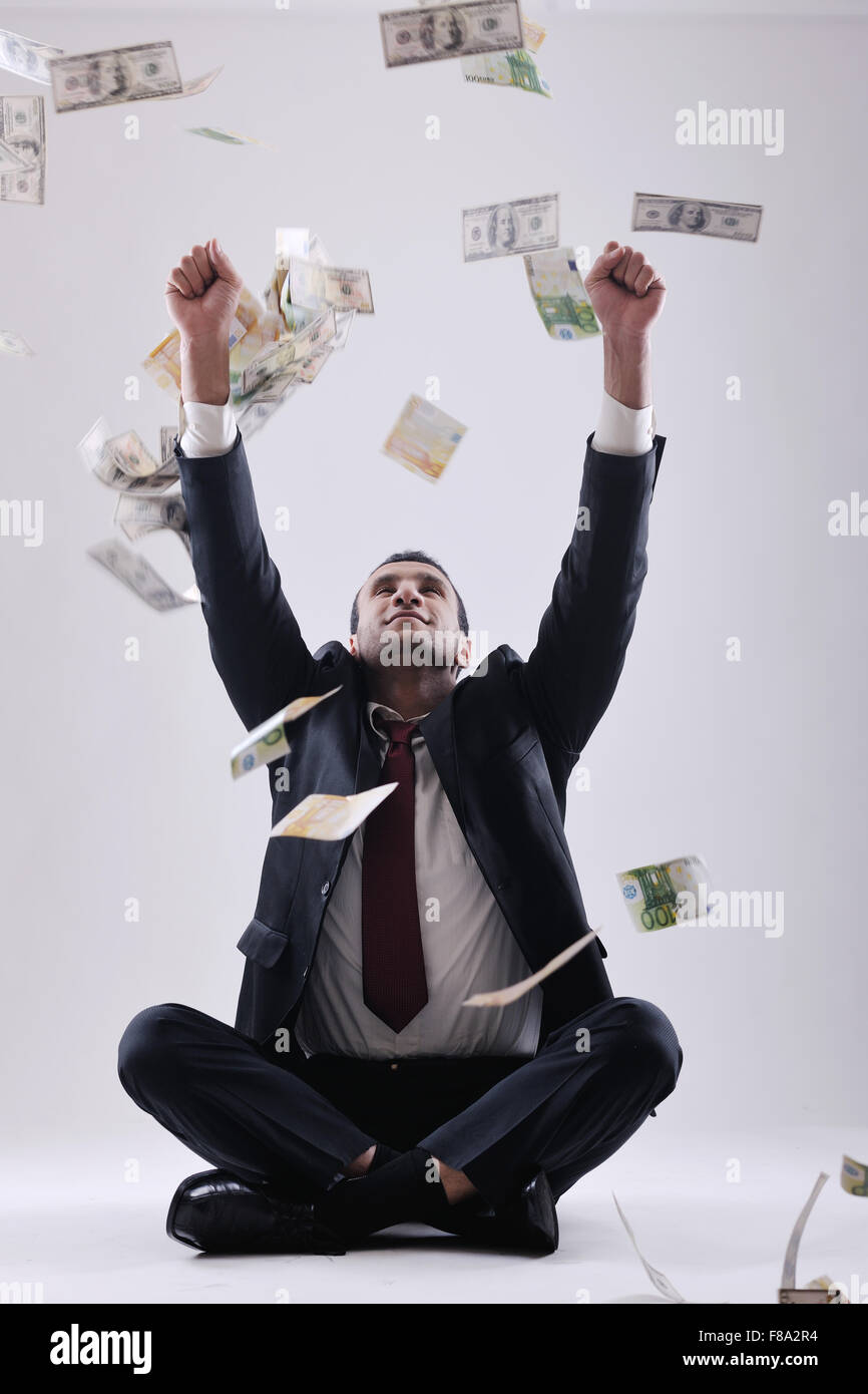 Portrait of a business man holding and catch falling money bills ...