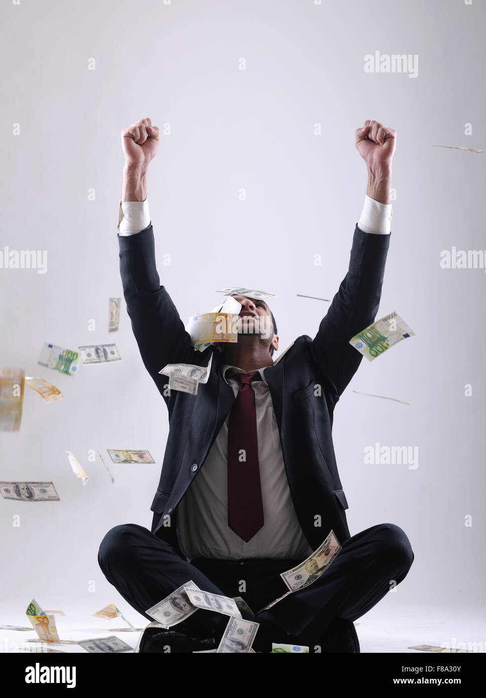 Portrait of a business man holding and catch falling money bills ...