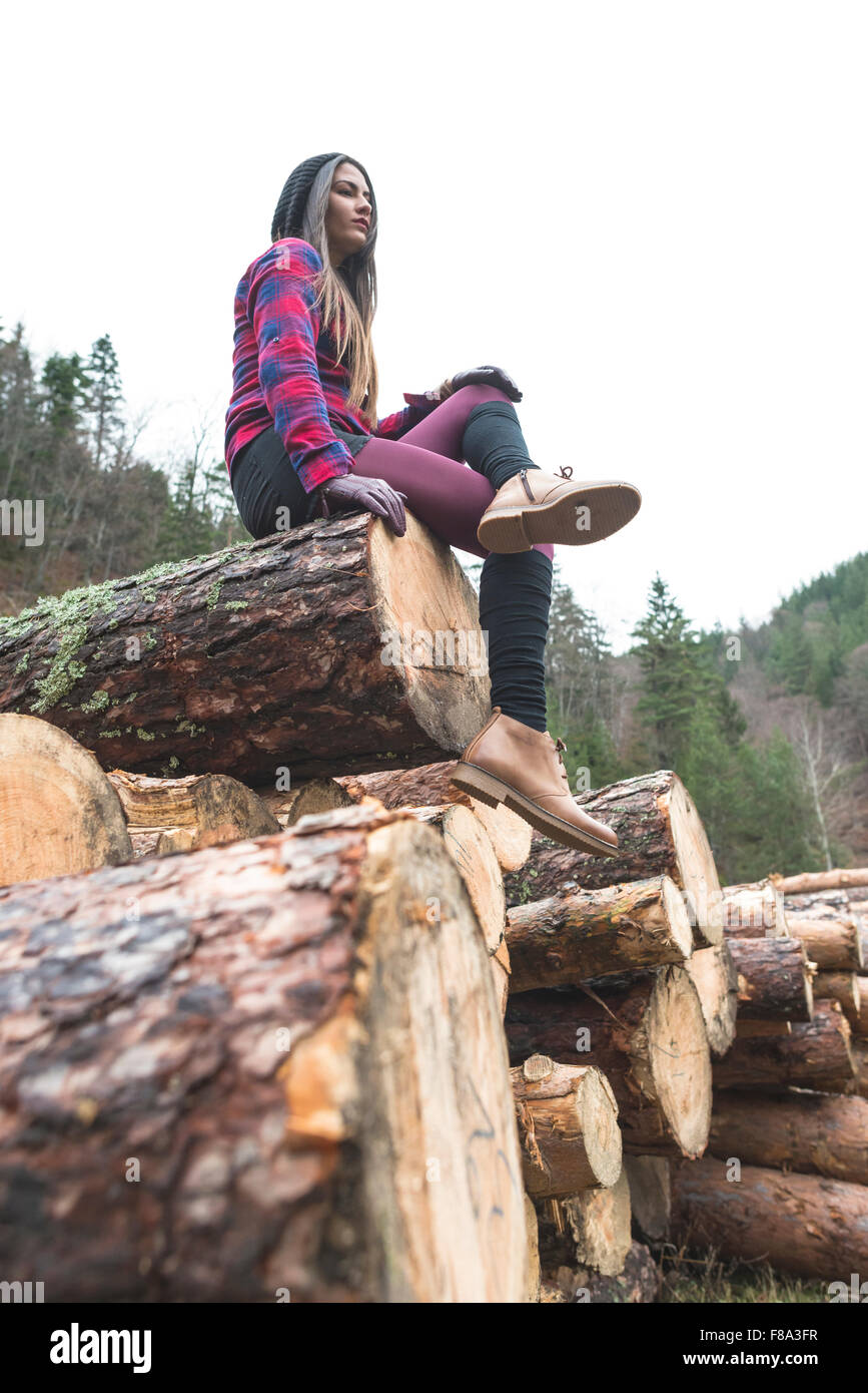 Young woman on wood logs Stock Photo - Alamy