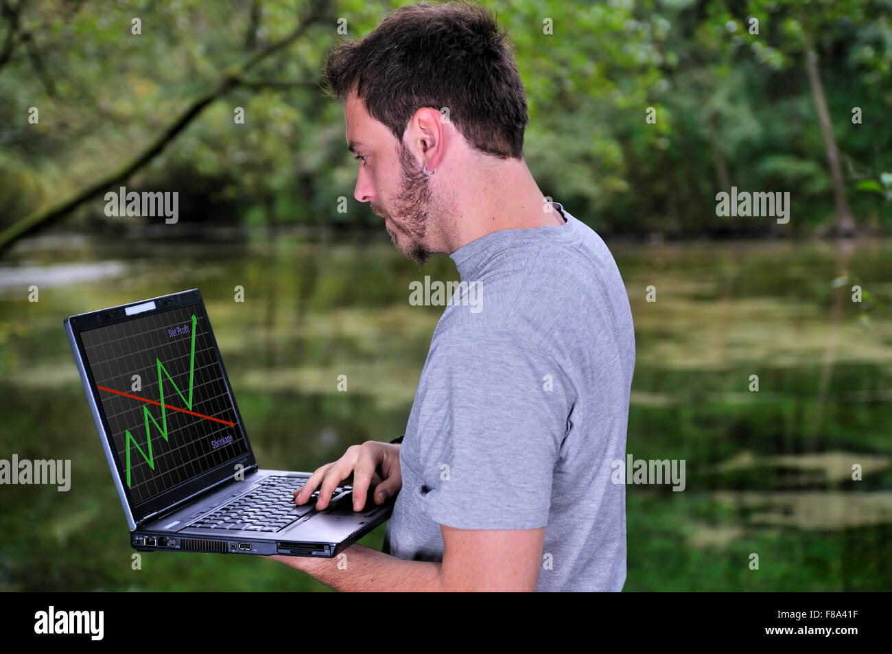 one young businessman working on laptop outdoor with green nature in ...
