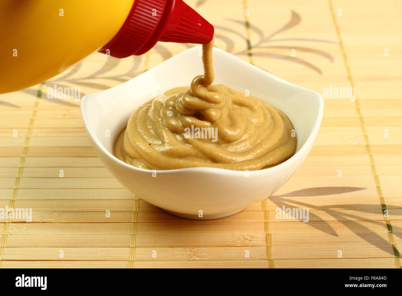 Pouring mustard into bowl Stock Photo - Alamy