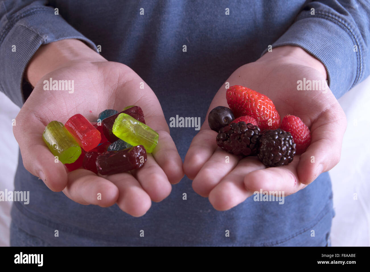 candy and fruit in hands Stock Photo - Alamy