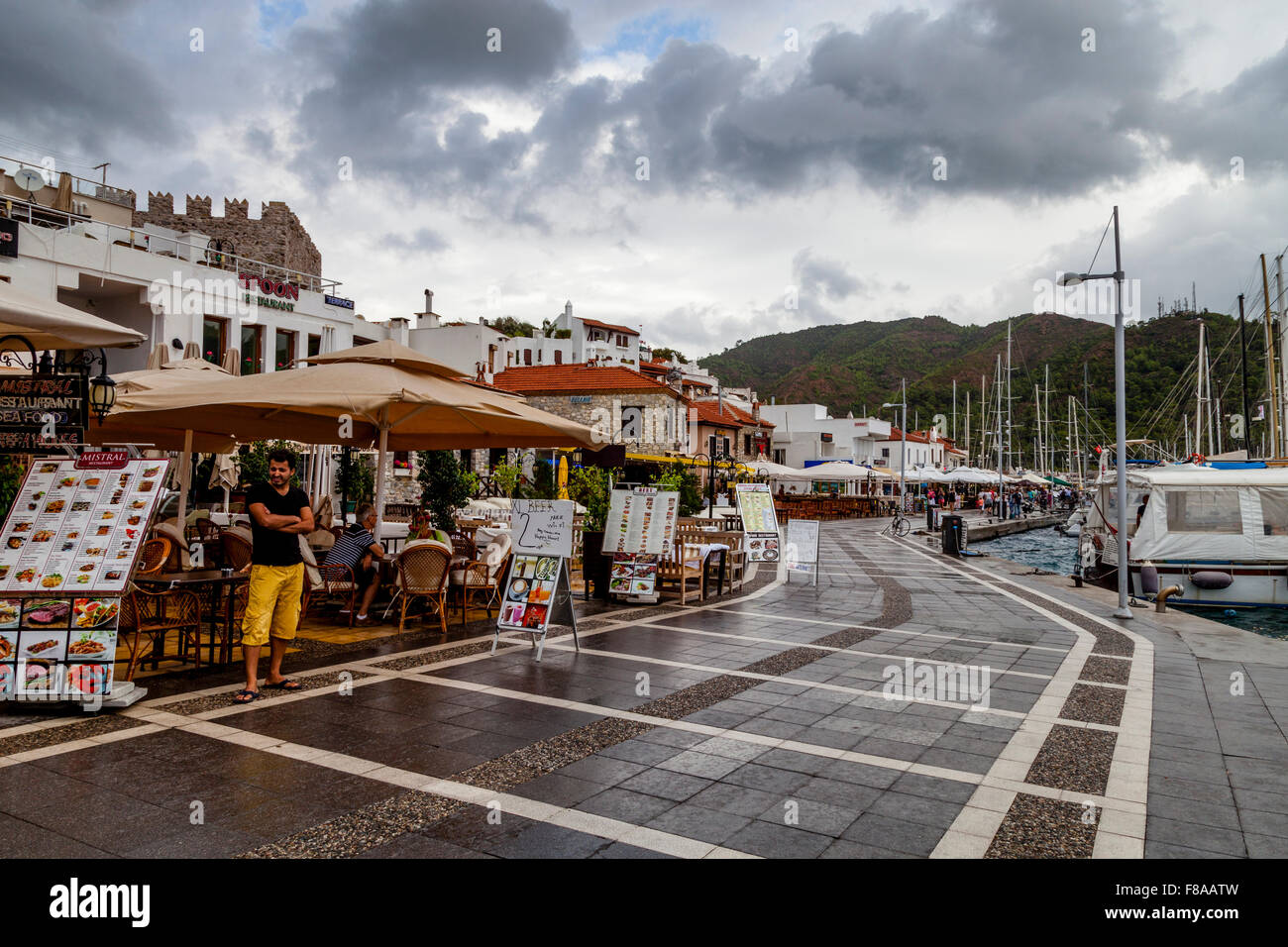 A Restaurant Worker Waits In The Rain For Passing Tourists, Marmaris ...