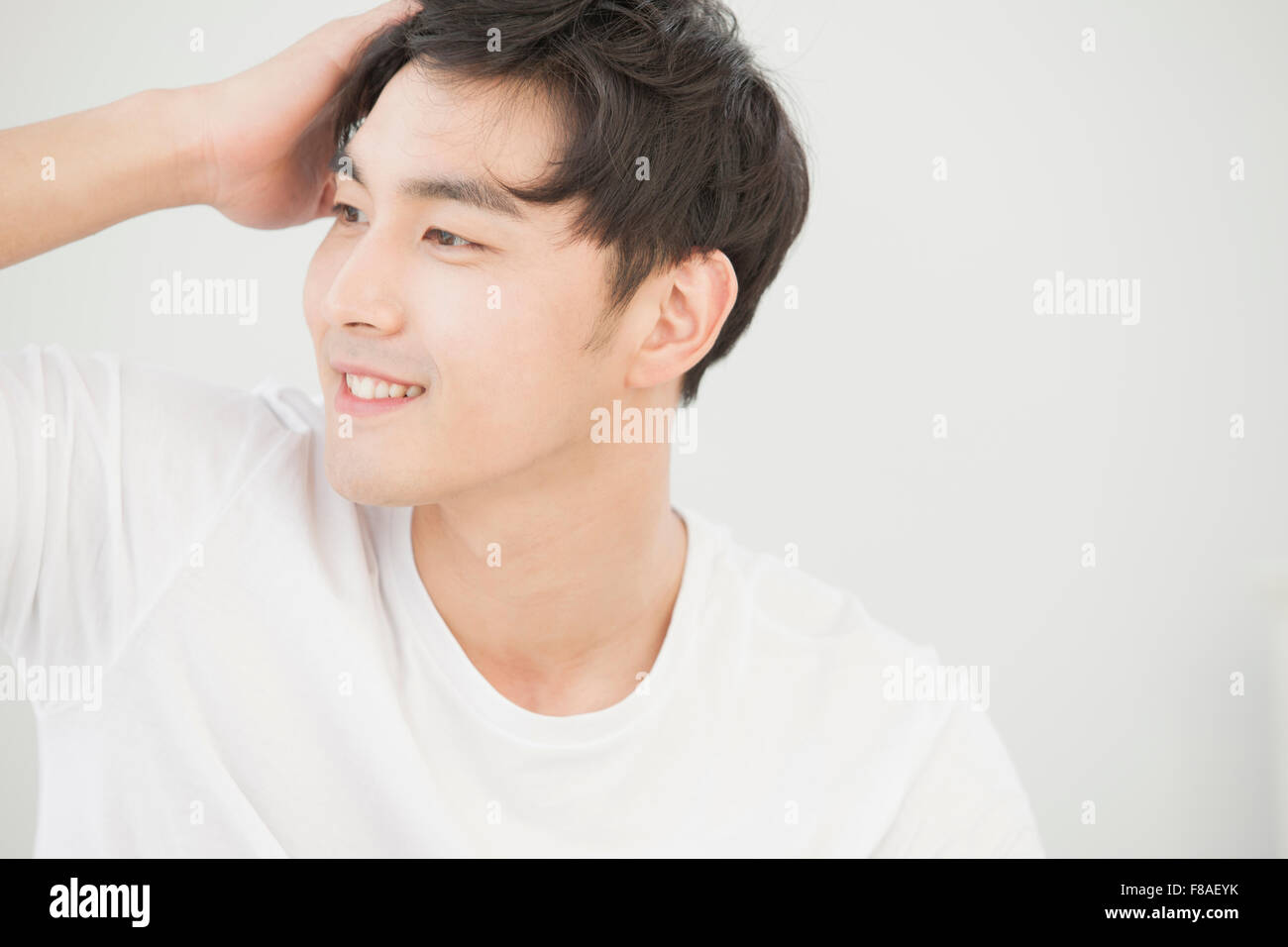 Smiling man putting his hand on his head Stock Photo - Alamy