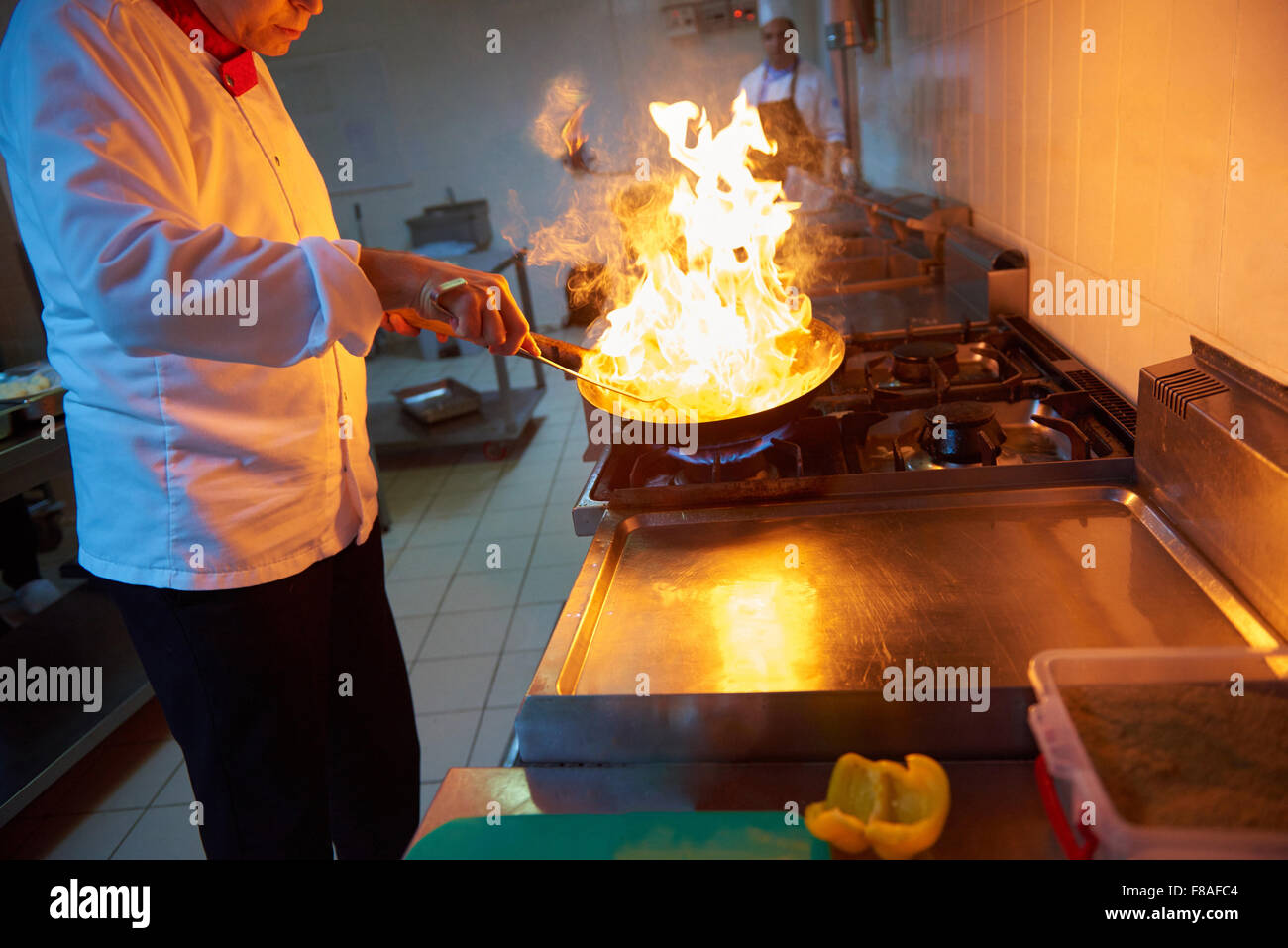 chef in hotel kitchen prepare vegetable food with fire Stock Photo - Alamy