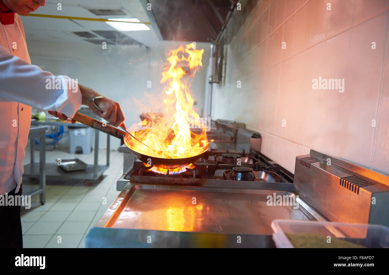 chef in hotel kitchen prepare vegetable food with fire Stock Photo - Alamy
