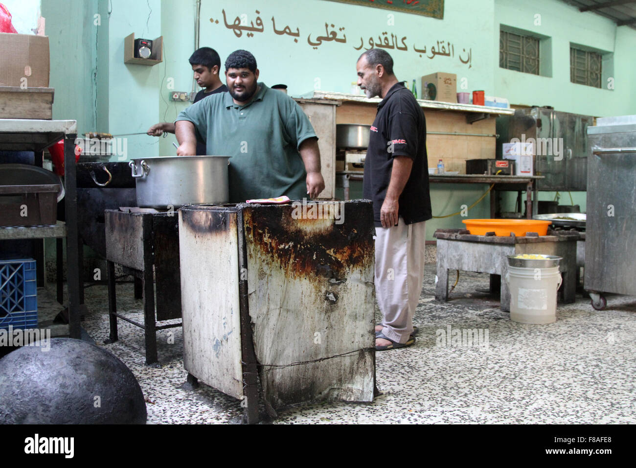 A chef in a kitchen attached to a Bahrain Shia mosque cook food for a ...