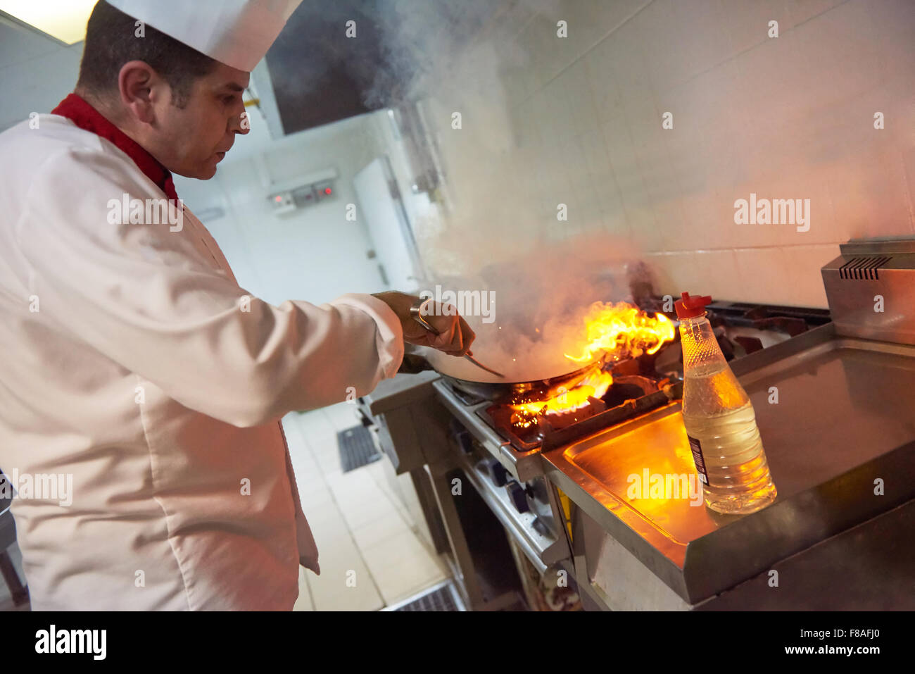 chef in hotel kitchen prepare vegetable food with fire Stock Photo - Alamy