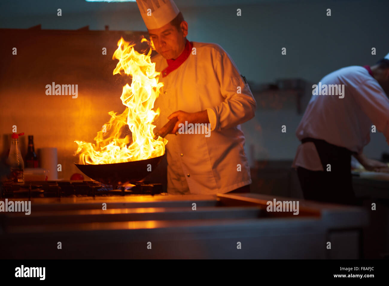 chef in hotel kitchen prepare vegetable food with fire Stock Photo - Alamy
