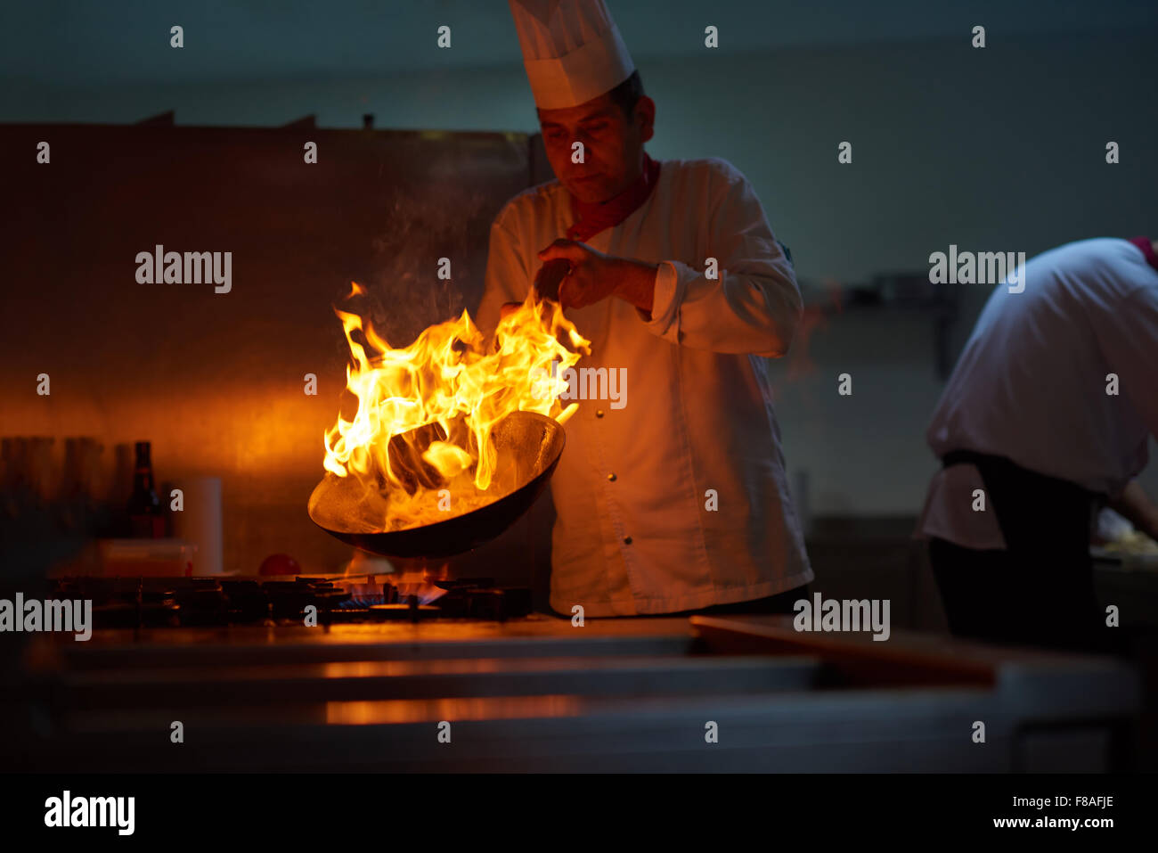 chef in hotel kitchen prepare vegetable food with fire Stock Photo - Alamy