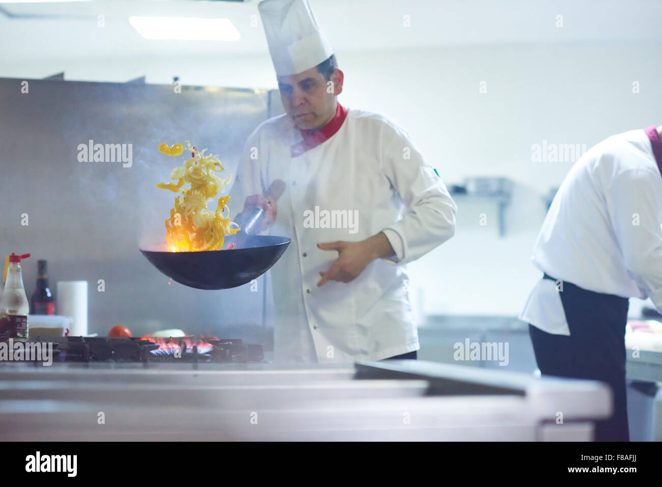 chef in hotel kitchen prepare vegetable food with fire Stock Photo - Alamy